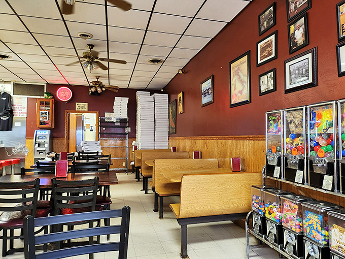 Red walls, wooden booths, and ceiling fans create that classic pizzeria atmosphere where time stands still and calories don't count.