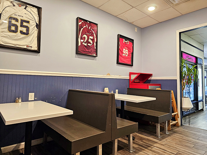 Sports jerseys watch over diners like sandwich guardian angels. The blue wainscoting adds just enough charm without distracting from the main event.