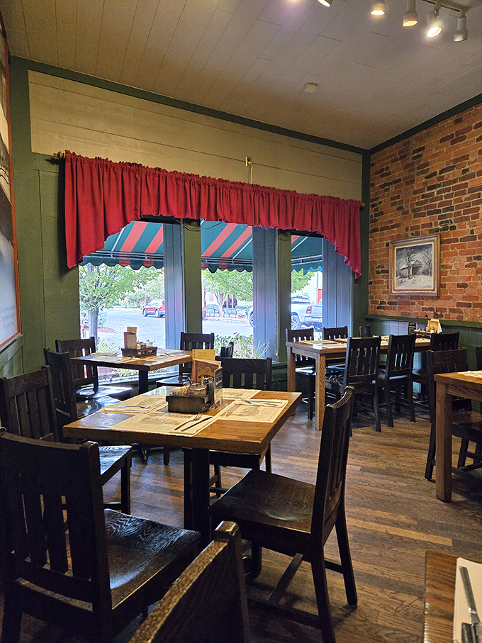 Red curtains frame windows overlooking Main Street, while wooden tables await hungry patrons in a dining room that feels both spacious and cozy.
