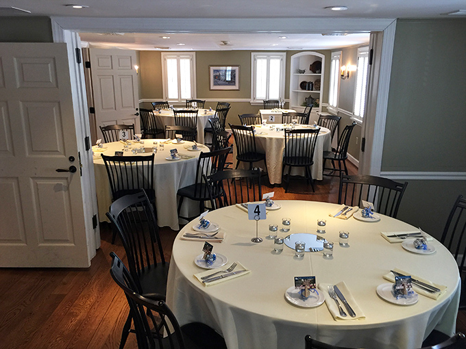 The dining room balances elegance and approachability, where white tablecloths say "special occasion" while Windsor chairs whisper "make yourself at home."