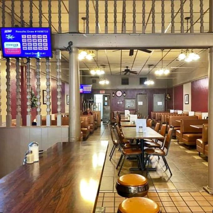 A dining room where lottery dreams and breakfast specials coexist. Those wooden dividers have witnessed decades of first dates, family gatherings, and solo meals enjoyed without judgment.