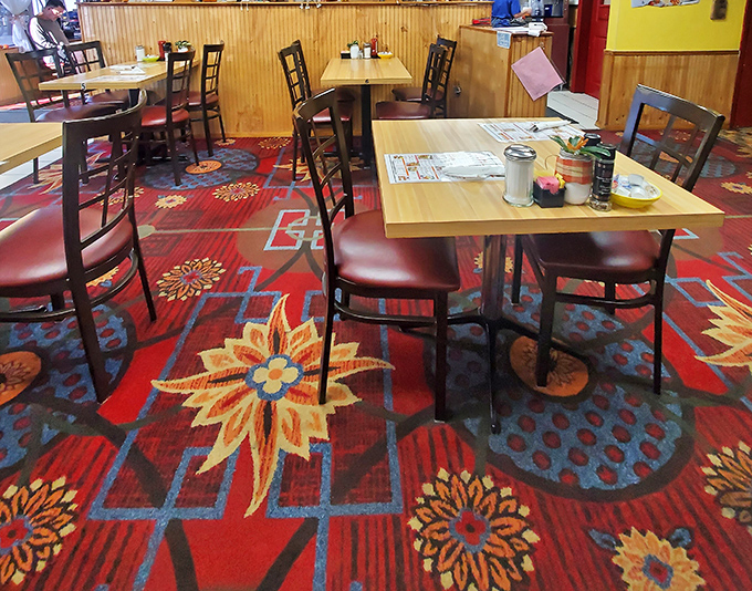 The vibrant carpet and simple furnishings create that classic diner vibe where great food memories are made one plate at a time.