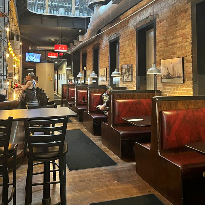 Exposed brick walls and wooden booths create that rare atmosphere where both first dates and family reunions feel equally at home.