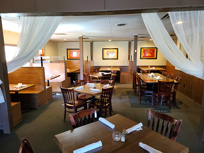 Soft white curtains frame dining areas like stage sets for your meal's performance, creating intimate spaces within the larger restaurant.