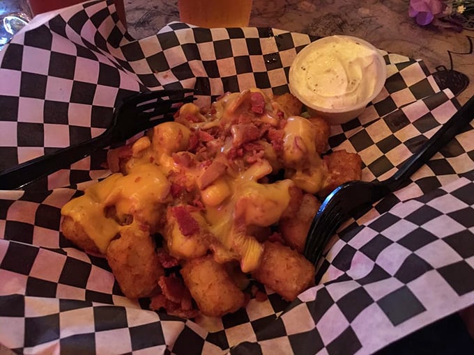 Tater tots living their best life under a blanket of melted cheese and bacon. Comfort food that understands the assignment.