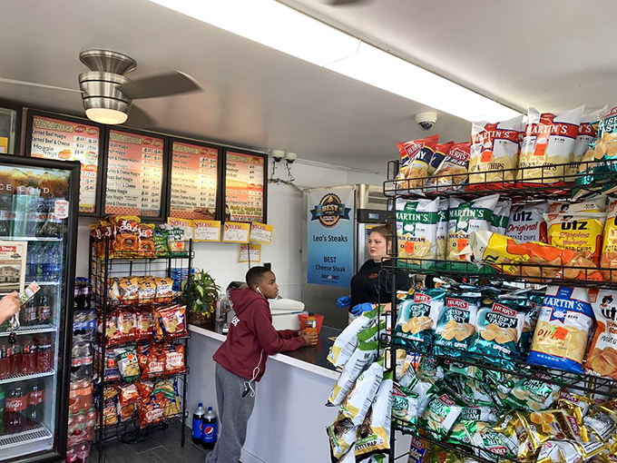 Chips, snacks, and sandwich-making magic await at the counter. The menu boards have probably looked the same for decades.