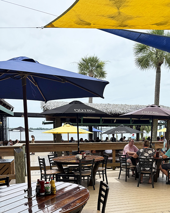 Umbrellas in navy and yellow create a patchwork of shade while the water view reminds you why Florida dining is in a league of its own.