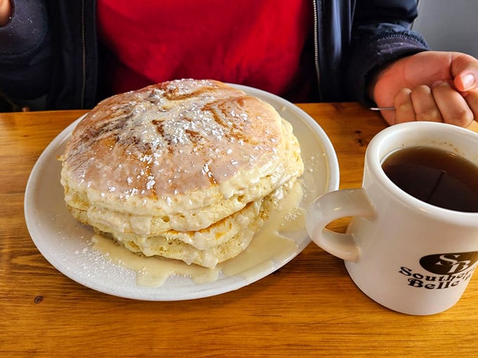 Pancakes stacked higher than your weekend expectations. That dusting of powdered sugar is like snowfall on a perfect breakfast mountain.