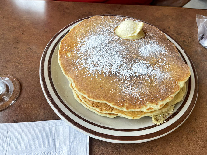 The pancake that ate Manhattan – a golden disk of fluffy perfection so large it threatens to escape the confines of its humble plate.