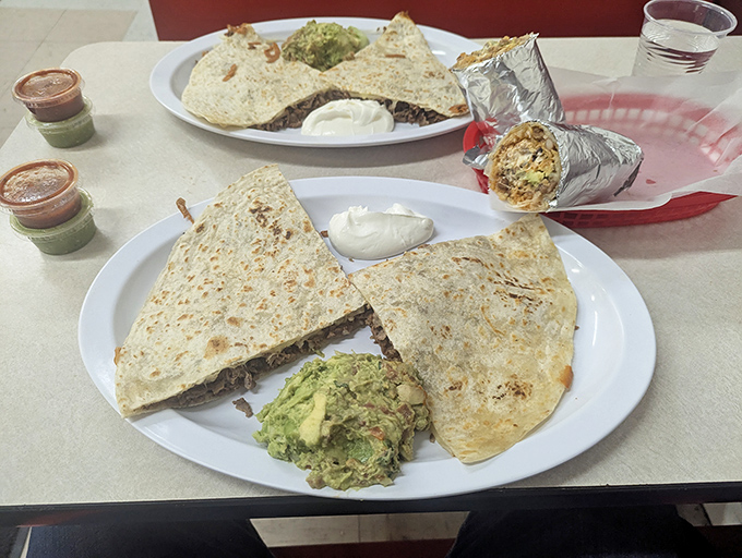 Quesadillas that could make a cheese connoisseur weep with joy, served with generous sides of guacamole and sour cream for proper dipping protocol.