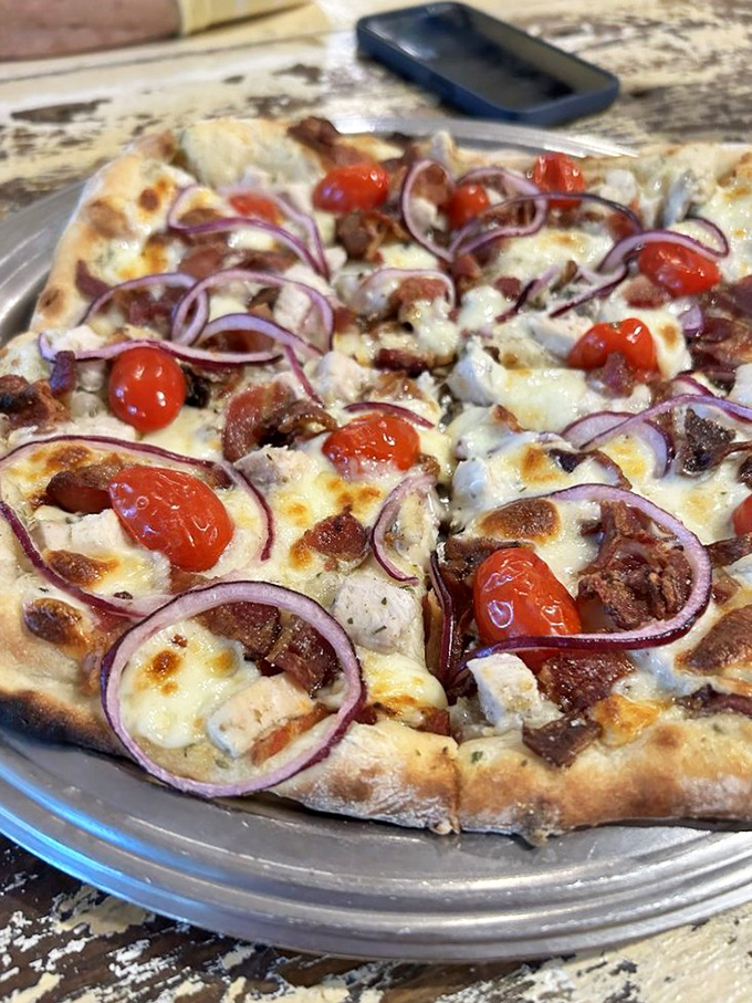 A pizza that's not afraid to wear its ranch dressing proudly, with red onions and cherry tomatoes adding pops of color and flavor.