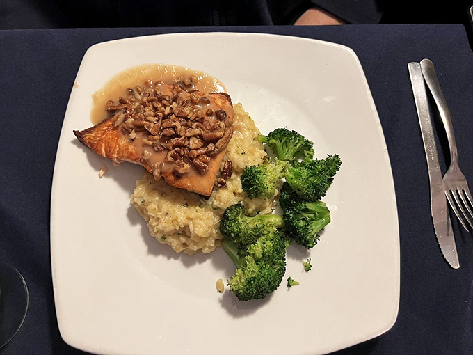 Salmon that looks like it's wearing its Sunday best, perched on risotto with broccoli standing guard. Elegant simplicity at its finest.
