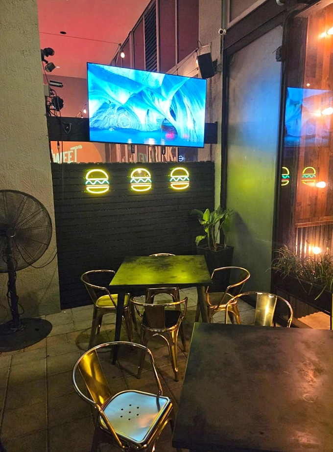 Neon burger signs illuminate this outdoor sanctuary where Miami nights and comfort food create the perfect urban oasis.