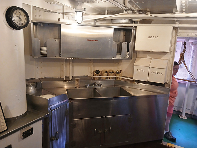The galley's pristine organization would make any tiny-home enthusiast jealous—bread, sugar, and coffee containers neatly labeled for life at sea.