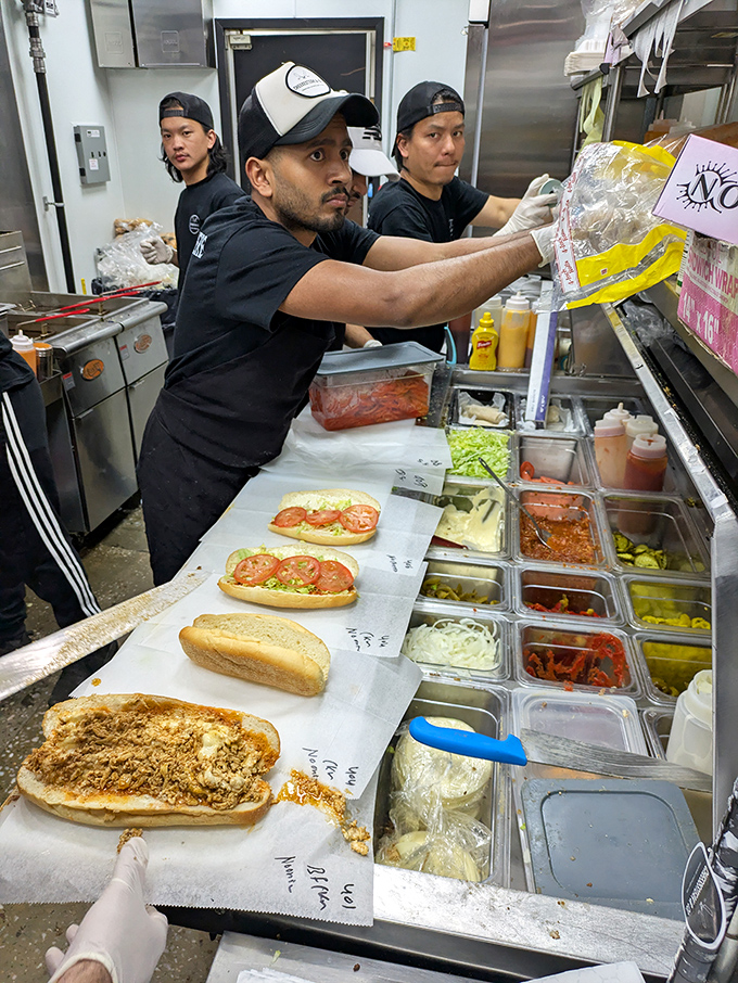 The kitchen crew works with the precision of surgeons and the passion of artists. These are the hands that make sandwich dreams come true.