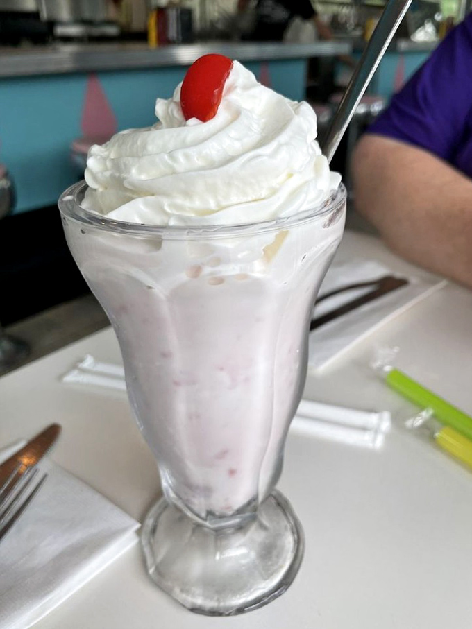 A proper strawberry shake topped with whipped cream and a cherry—proof that sometimes the classics need absolutely no improvement.