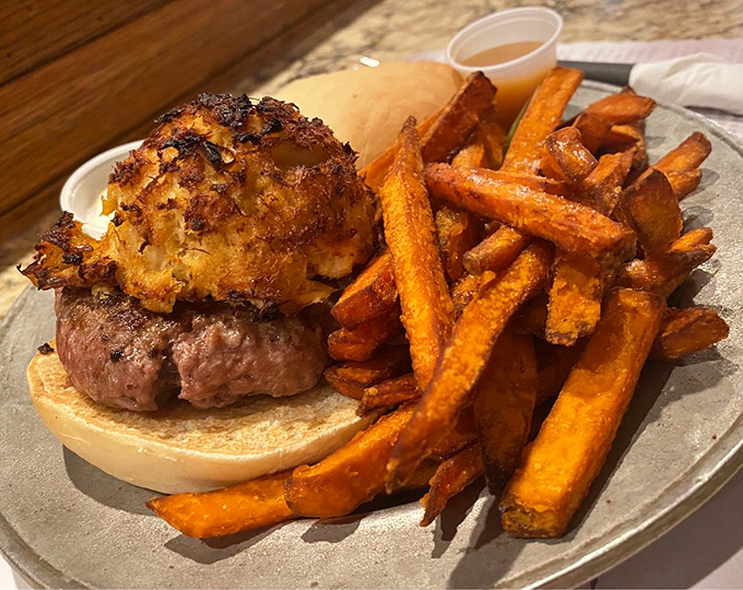 This isn't just a burger&mdash;it's a surf and turf masterpiece topped with what appears to be crab, proving that sometimes more really is more.