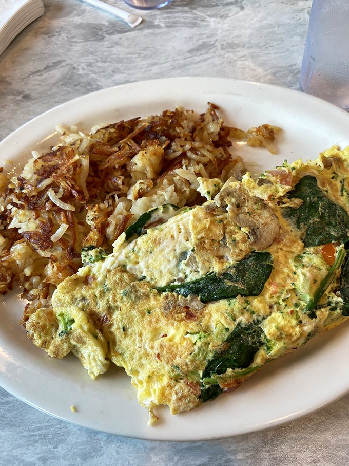 Garden-fresh meets griddle-perfect in this veggie omelet. Those crispy-edge hash browns aren't just a side dish&mdash;they're essential supporting characters.