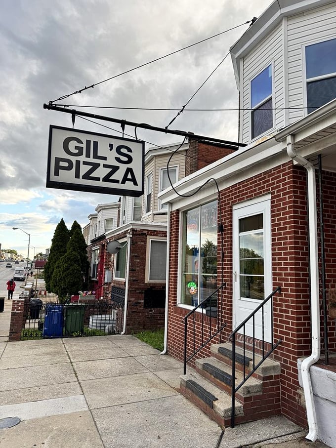 Gil's Pizza's hanging sign swings like a beacon for the pizza-hungry. This humble storefront in Baltimore hides magnificent flavor within.