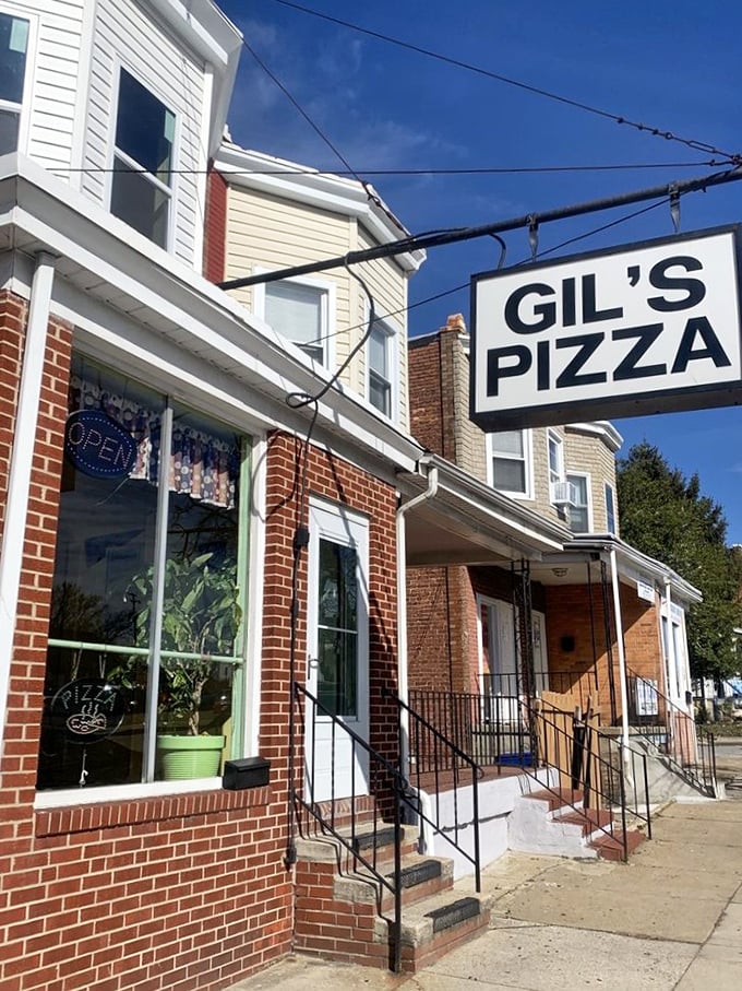 The classic brick facade of Gil's Pizza speaks of neighborhood tradition. That simple "OPEN" sign is all the invitation pizza lovers need.