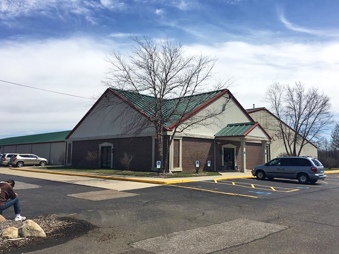 The welcoming entrance to I-76 Antique Mall, where American flags flutter in the breeze and vibrant red maples frame the doorway to nostalgia.