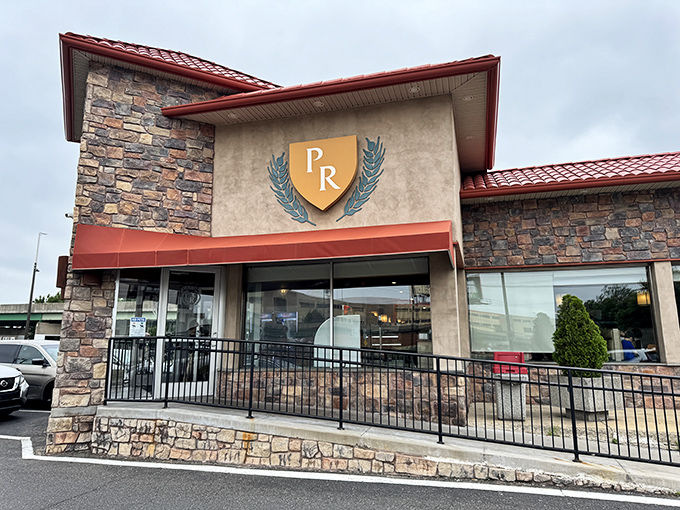 The stone facade and iconic "PR" shield logo of Penrose Diner stands as a beacon of breakfast hope on Penrose Avenue, promising comfort food salvation inside.