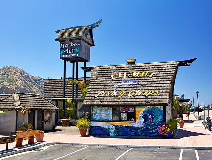 The iconic A-frame structure of Harbor Hut stands proudly against Morro Bay's blue skies, promising seafood treasures within its wooden walls.