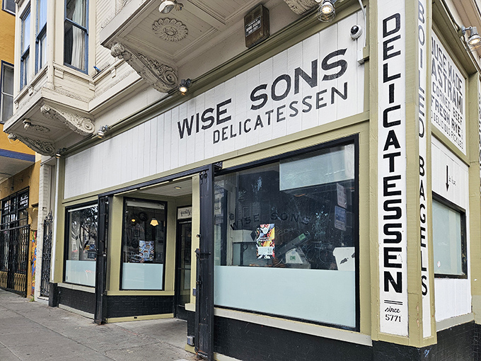 The unassuming storefront of Wise Sons on 24th Street hides culinary treasures that would make your bubbe weep with joy. Classic delicatessen signage promises authenticity within.