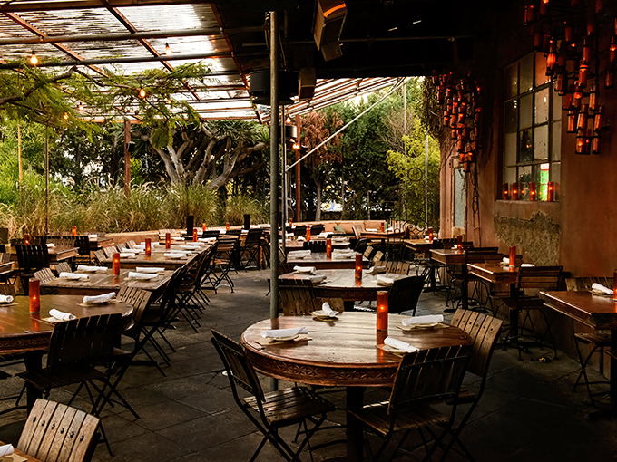 Habana's enchanting patio at dusk&mdash;where tropical foliage meets ambient lighting, creating the perfect backdrop for that life-changing flan experience.