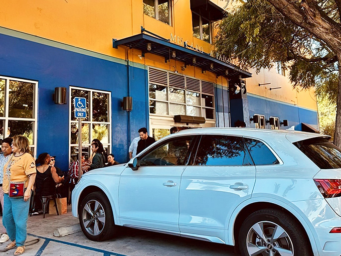 The vibrant blue and yellow exterior of Holbox stands out like a tropical island paradise in urban Los Angeles, complete with a line of eager seafood pilgrims.