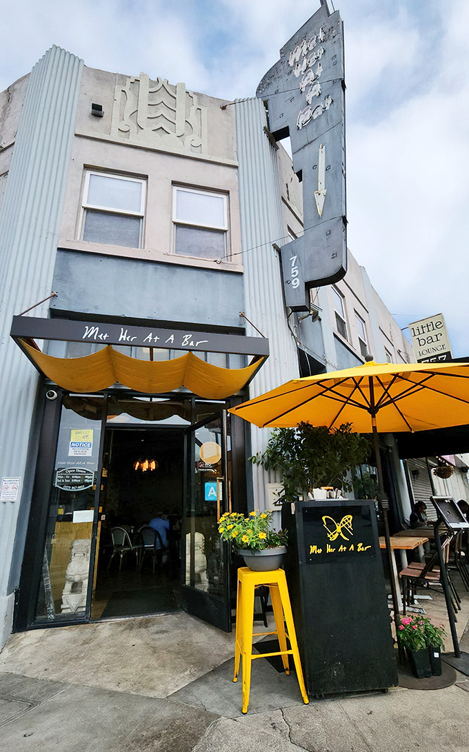 The Art Deco facade of Met Her At A Bar beckons with retro charm and sunny yellow accents, like a time capsule serving modern comfort food.