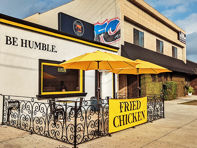 The humble storefront speaks volumes: bright yellow umbrella, wrought iron fence, and that "BE HUMBLE" mantra that perfectly sets the stage for Nashville-style chicken greatness.