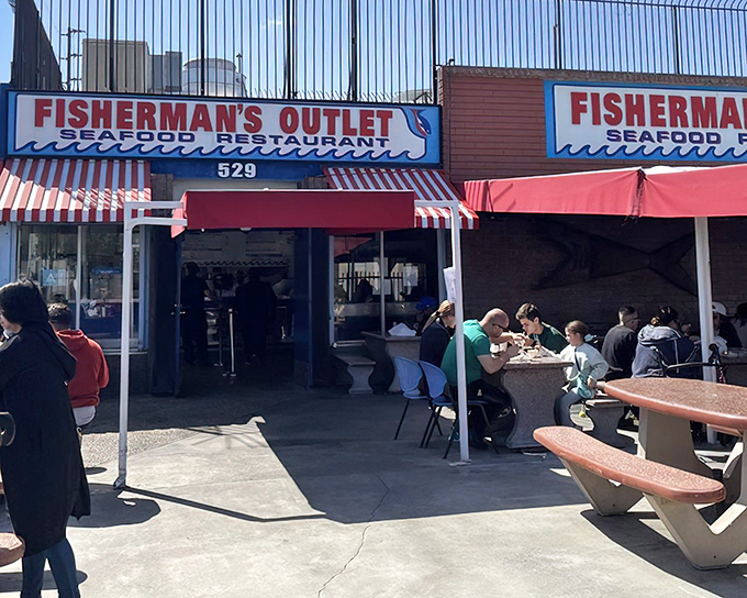 The red umbrellas at Fisherman's Outlet beckon like maritime flags signaling "fresh seafood ahead." This unassuming storefront hides treasures that would make Neptune himself line up.