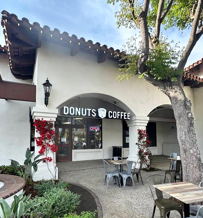 Mission-style charm meets donut paradise at JD Flannel's entrance, where bougainvillea frames the doorway like nature's own welcome committee.
