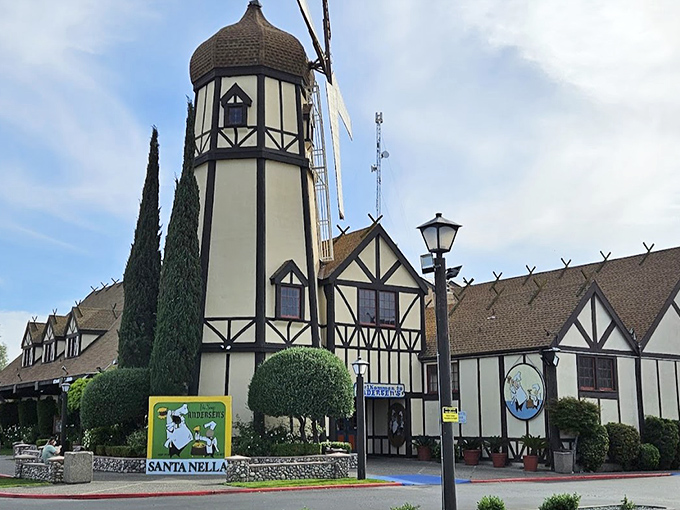 The iconic Tudor-style facade of Pea Soup Andersen's welcomes travelers with its charming "Velkommen" sign and colorful landscaping.