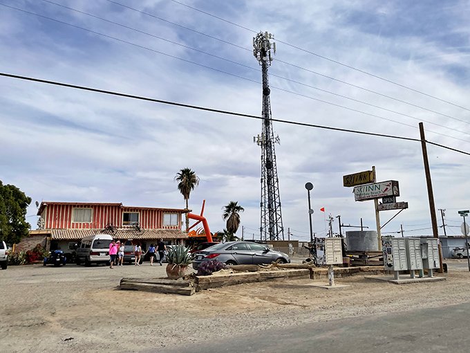 The iconic blue tube man waves you in like an old friend, standing guard outside this desert oasis where adventure awaits.
