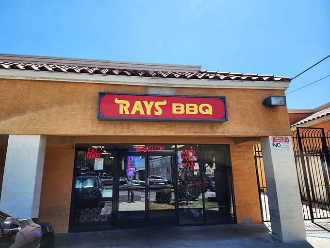The unassuming stucco exterior of Ray's BBQ might fool you, but that red sign is basically a smoke signal saying "barbecue paradise ahead."