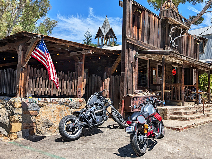 The Old West meets modern California at The Old Place's rugged exterior. Motorcycles parked outside this weathered wooden structure hint at the diverse crowd this legendary steakhouse attracts.