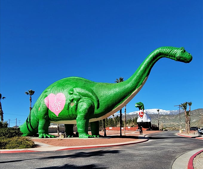 The famous pink Apatosaurus stands proudly against the desert sky, sporting a message of love that's as enormous as its prehistoric proportions.
