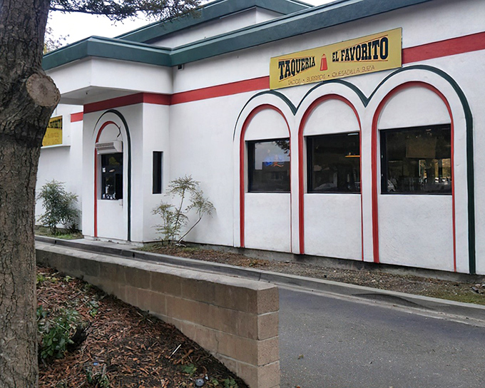 The unassuming exterior of Taqueria El Favorito, with its distinctive red arches, proves once again that culinary treasures often hide in plain sight.