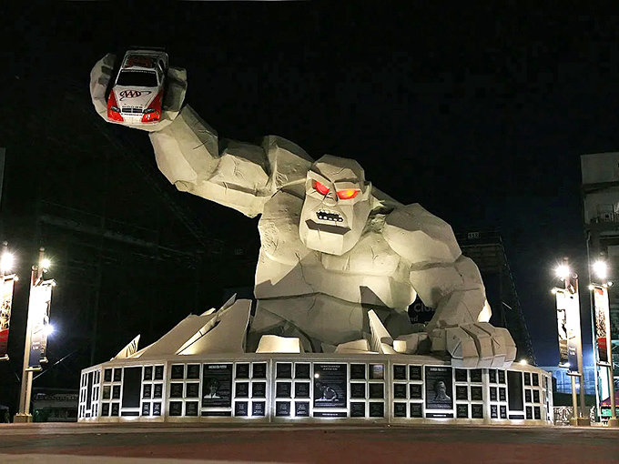 Miles the Monster looms large at night, his glowing red eyes and massive concrete form creating an otherworldly sentinel at Dover Motor Speedway's entrance.