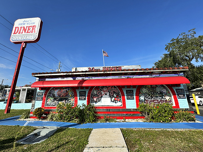 The classic red and blue sign beckons like a lighthouse for hungry souls&mdash;Joe's New York Diner stands ready to serve, 24 hours a day.