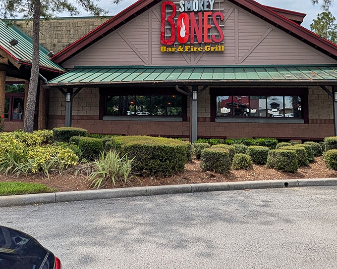 The rustic lodge-style exterior of Smokey Bones stands as a smoky oasis amid Florida's palm trees, promising barbecue salvation to meat lovers seeking refuge from theme park fare.