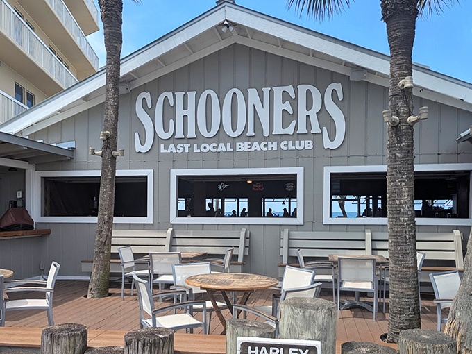 Schooners proudly announces itself as the "Last Local Beach Club," where palm trees stand guard and outdoor seating beckons with the promise of Gulf breezes.