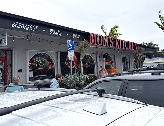 The red neon sign beckons like a lighthouse for hungry souls. Mom's Kitchen stands ready to rescue you from breakfast boredom.
