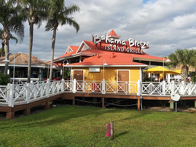 The iconic yellow and orange exterior of Bahama Breeze stands like a tropical oasis in Tampa, complete with that signature red roof that practically screams "vacation starts here!"