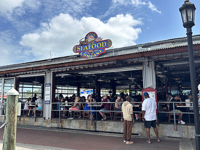 Weathered charm meets waterfront dining where yellow umbrellas promise shade and exceptional seafood awaits discovery.