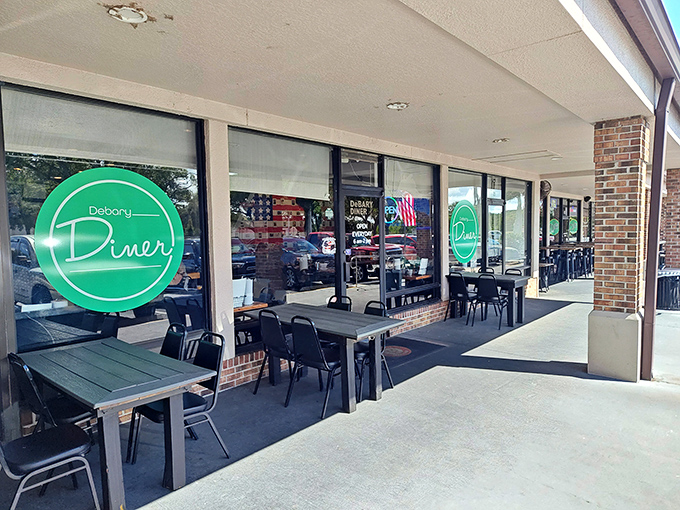The iconic green sign welcomes hungry travelers to DeBary Diner, where outdoor seating offers a perfect perch for people-watching between bites of comfort food.