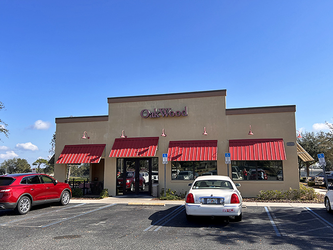 The welcoming tan exterior with bright red awnings promises what every BBQ pilgrim seeks – authentic flavor without pretension.