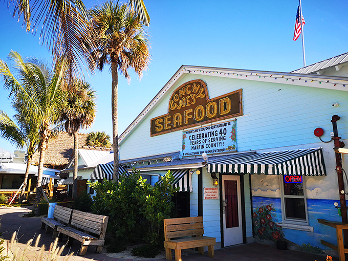 The classic Florida seafood joint equation: palm trees + weathered white building + bold "SEAFOOD" sign = paradise found. No reservations required for the memories.
